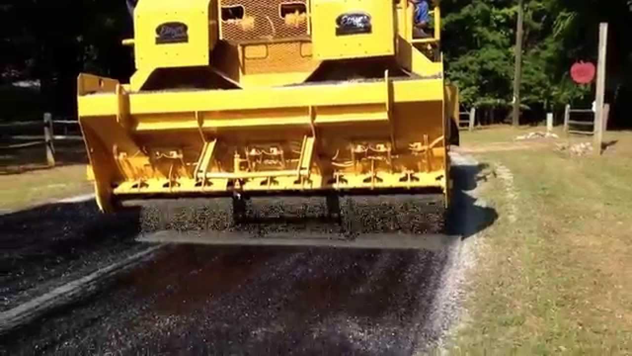 Tar and chipping a private road in Virginia done right 3rd layer - YouTube