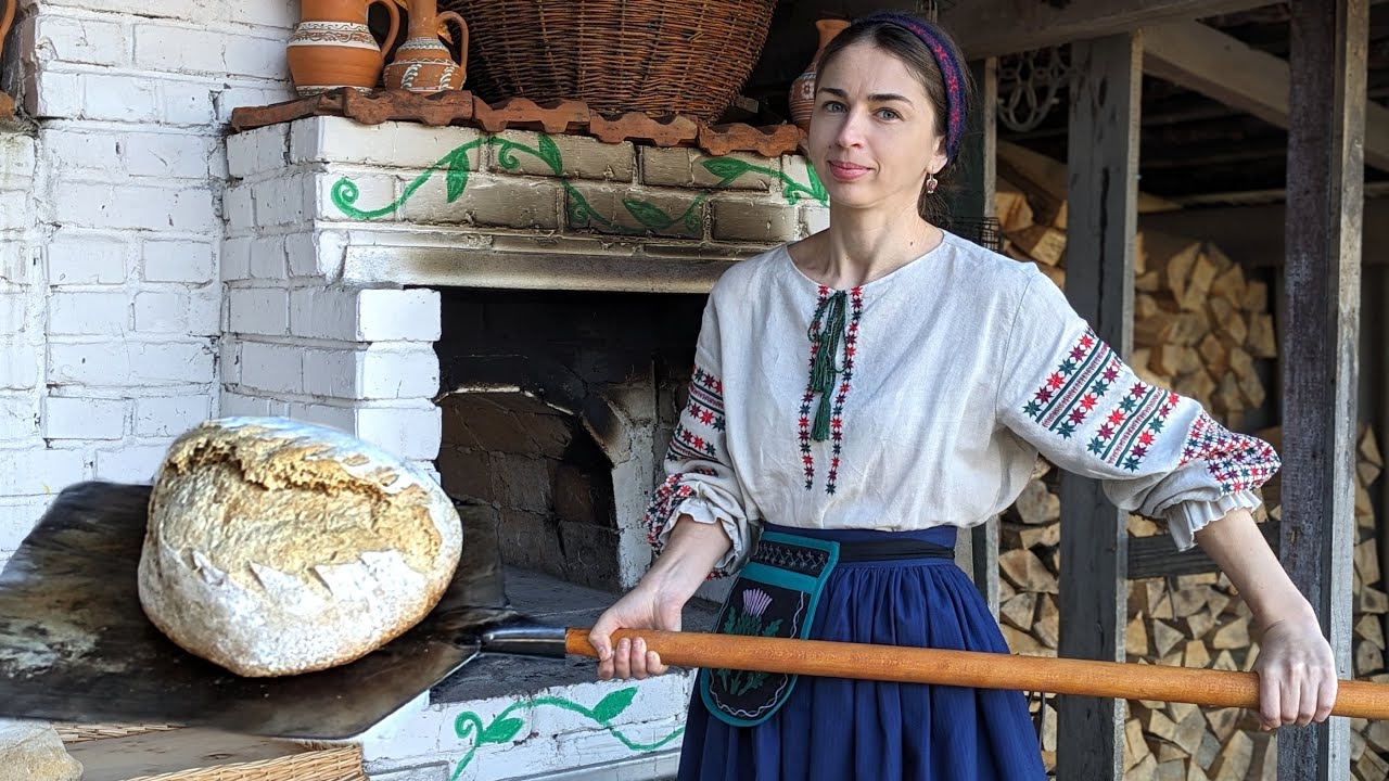 Woman is baking her first bread with whole grain flour in village oven ...