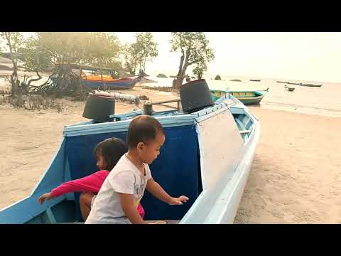 Asiknya adek dan kaka Menelusuri pantai di sore hari