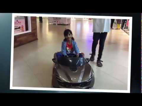Baby's grow up. ...playing with cars in a shopping mall with family ...