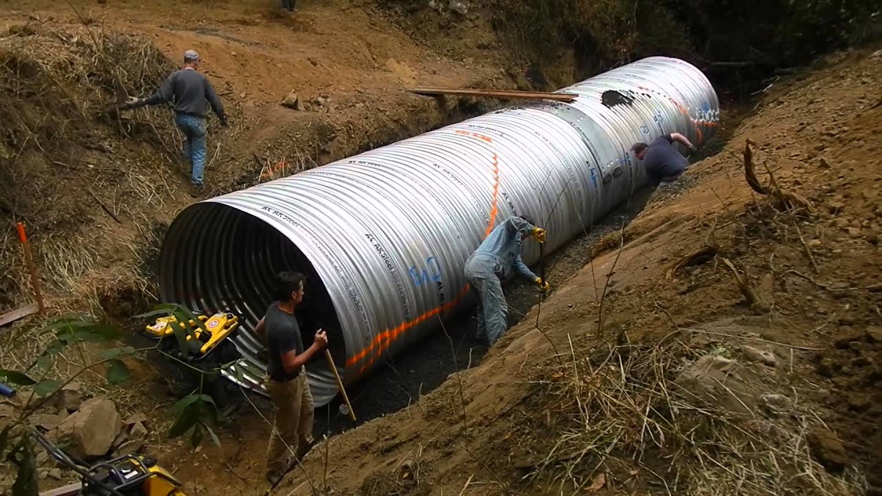 Setting rock next to the culvert - YouTube