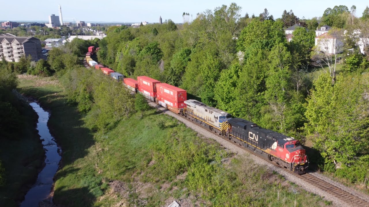 Awesome Aerial 4K View! Big Stack Train CN 120 w/Inspection Car & DPU Heading Out of Moncton, NB ...