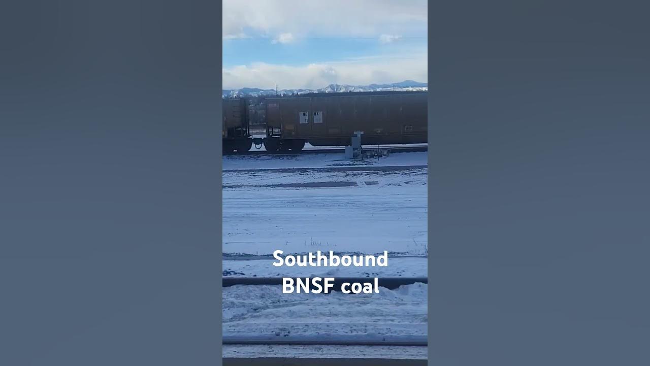 Southbound BNSF coal train passing RTD I-25 & Broadway station. South of downtown Denver, CO ...