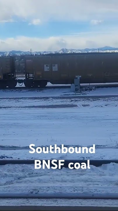 Southbound BNSF coal train passing RTD I-25 & Broadway station. South of downtown Denver, CO ...