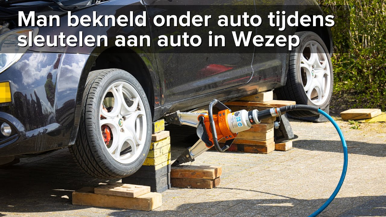 Man bekneld onder auto tijden sleutelen aan voertuig Koolzaadakker ...