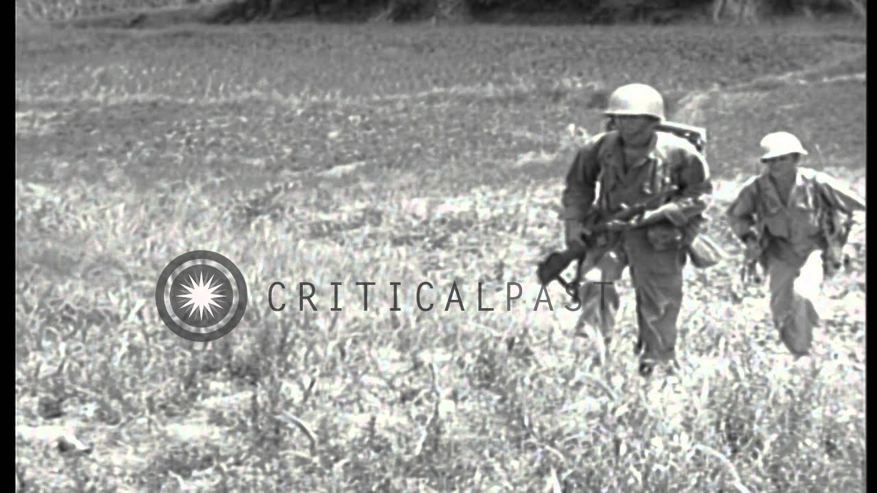 US 96th Division,381st Infantry soldiers advance across a field in ...