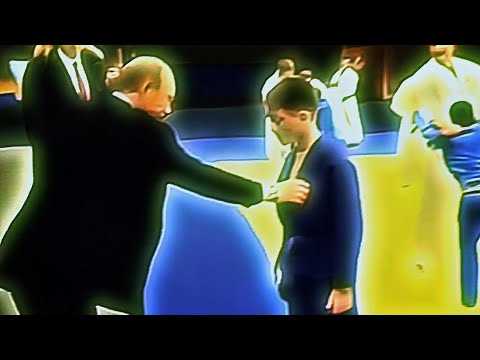 Vladimir Putin demonstrates a grip to a young judoka 