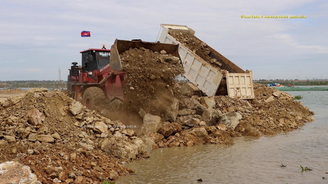MATADOR Wheel Loader And Dump Truck Unloading Limestone Fill At Water ...