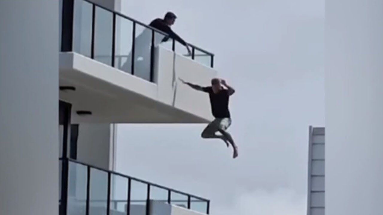 Man takes death-defying leap off balcony to avoid police - YouTube