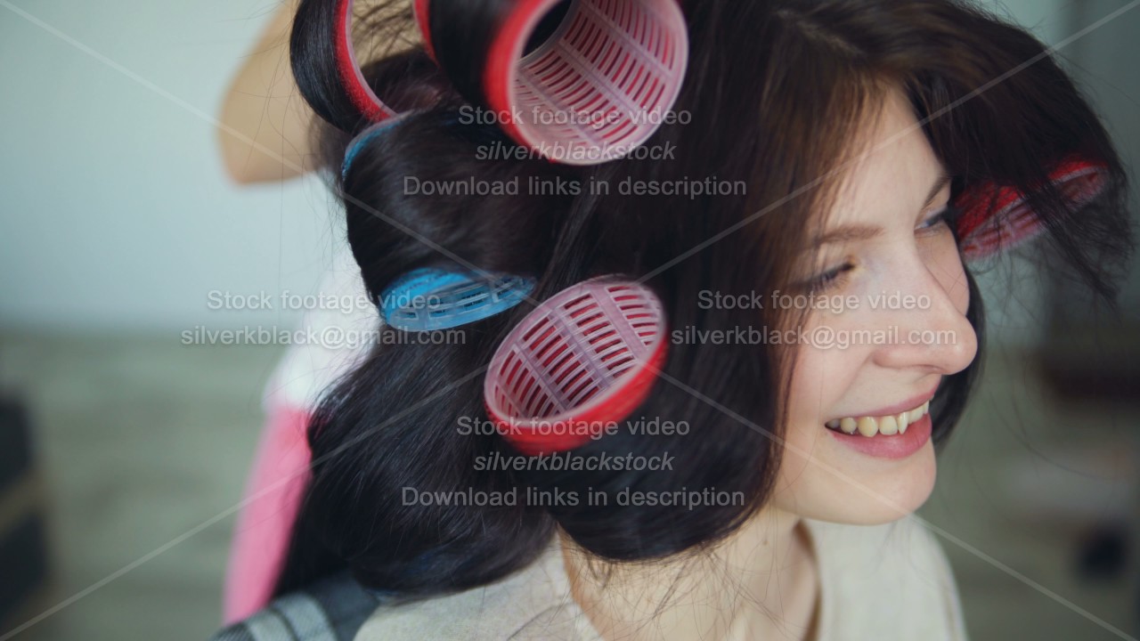 Closeup of happy women friends make fun curler hairstyle each other and ...