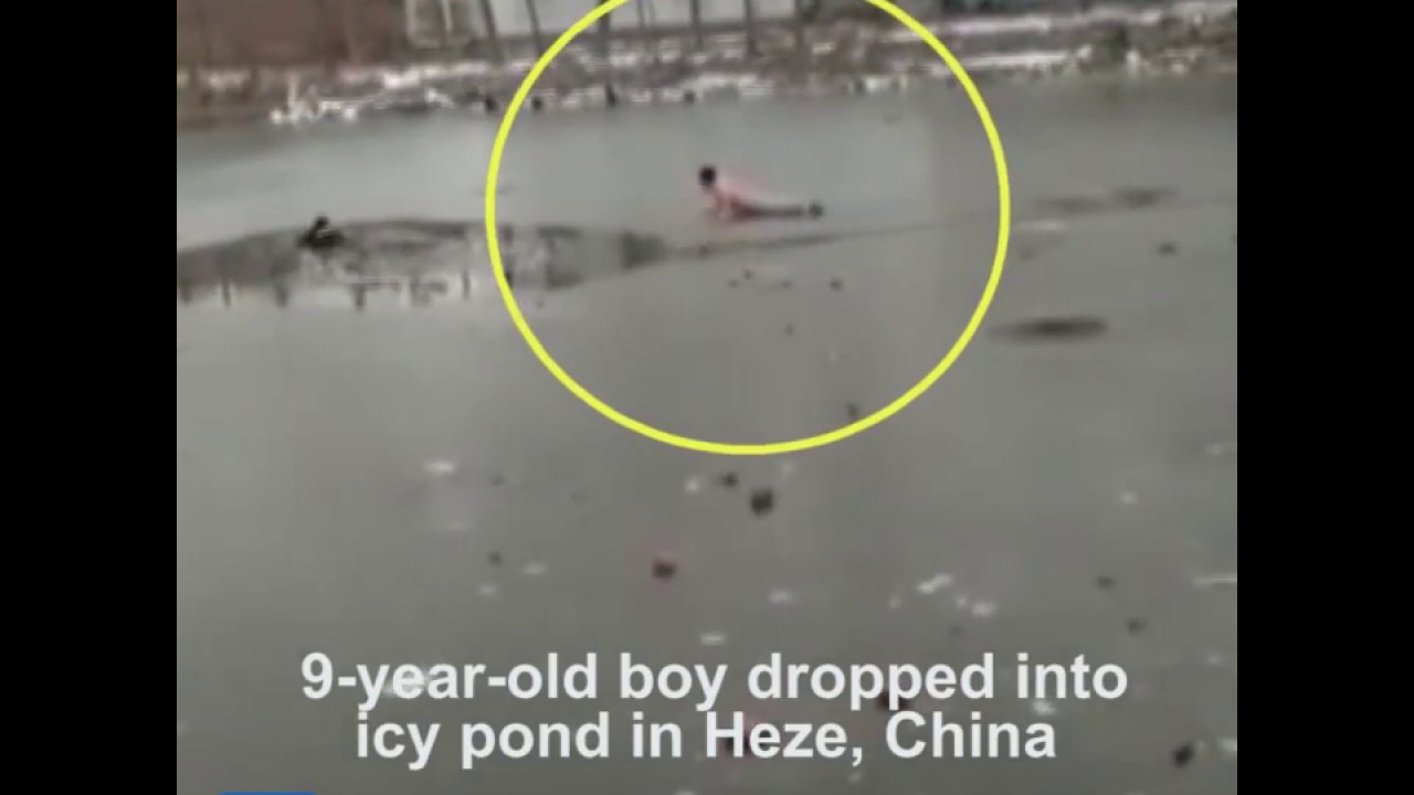 Man crawls across ice to rescue boy trapped in icy pond - YouTube