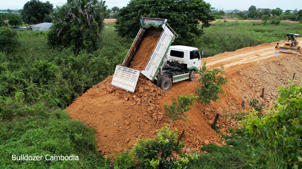 Beautiful Mini Dump Truck Unloading Dirt Into Slope And Small Bulldozer ...