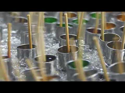 Popsicles in metal tubes in a bed of crushed ice quickly turning left ...