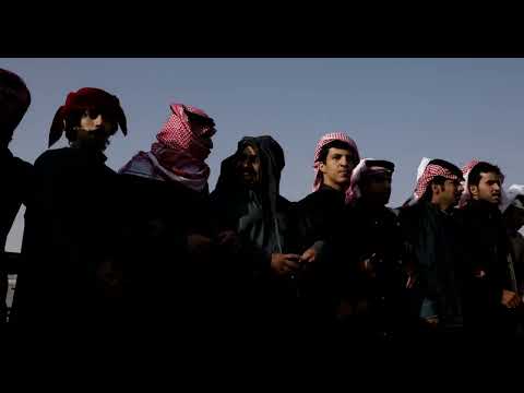 Saudi men dancing in line during King Abdul Aziz Camel Festival, Rimah, Saudi Arabia