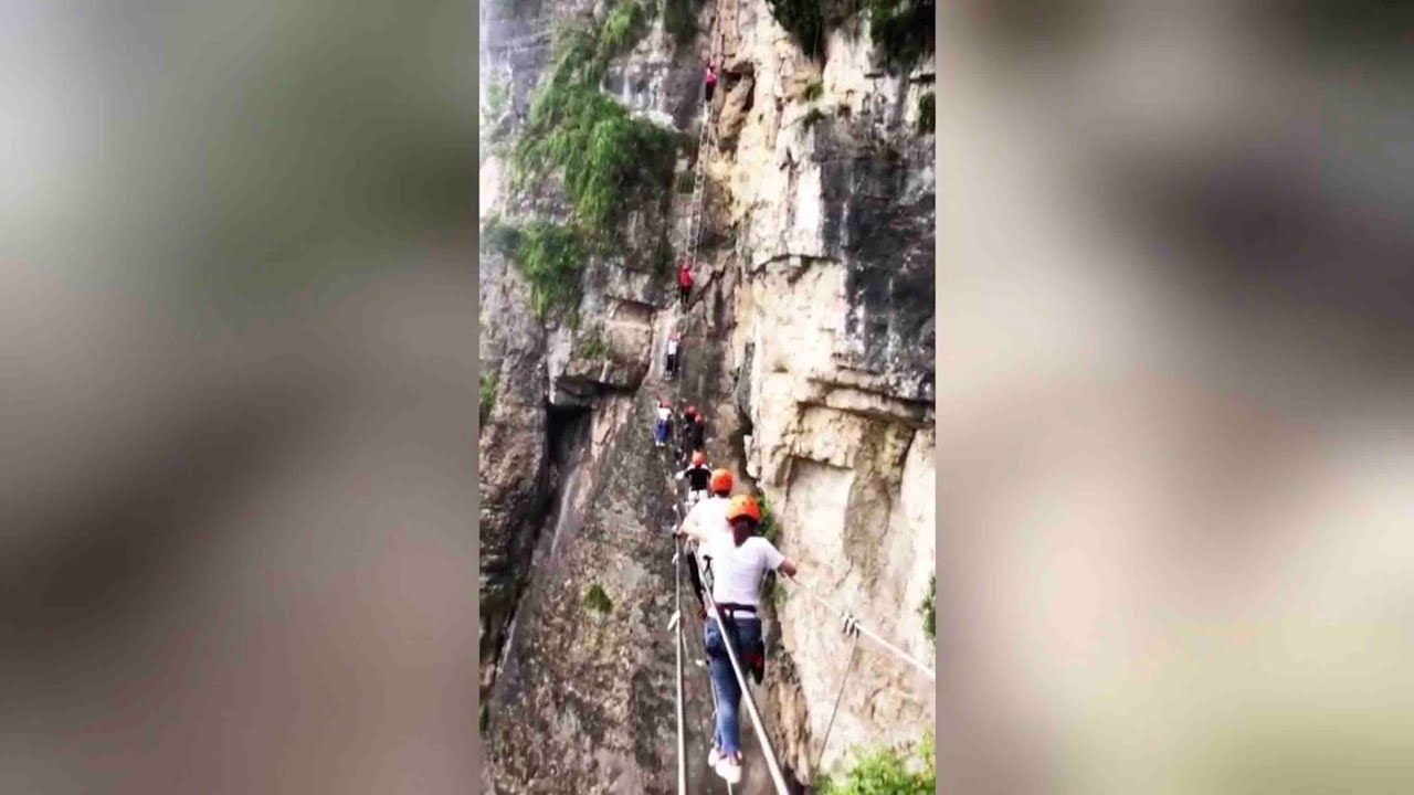 Daredevil tourists climb vertical cliff in C. China - YouTube