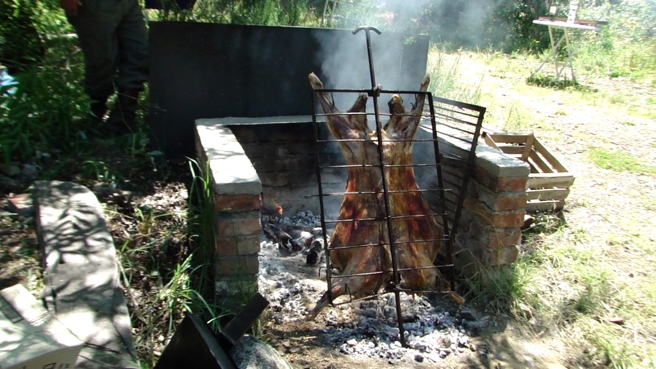 Cordero patagónico asado a la cruz y macramé a orilla del lago. El ...