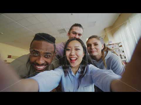 Point of view of asian girl holding smartphone taking selfie photos with cheerful classmates and