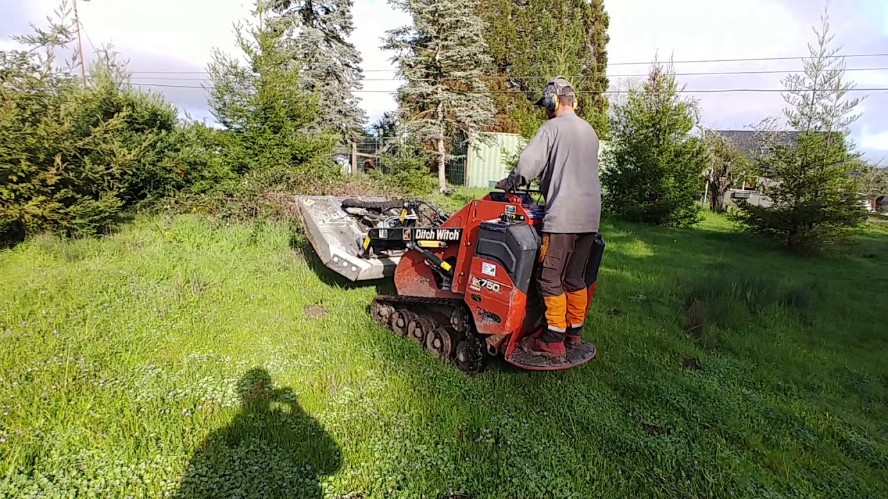 SK750 Running a BUSH MASTER MOWER - YouTube