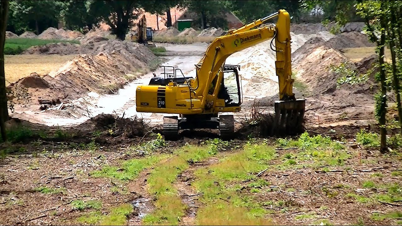 Komatsu PC210 LC rodet Baumwurzeln / Komatsu PC210 LC with a grab rake ...