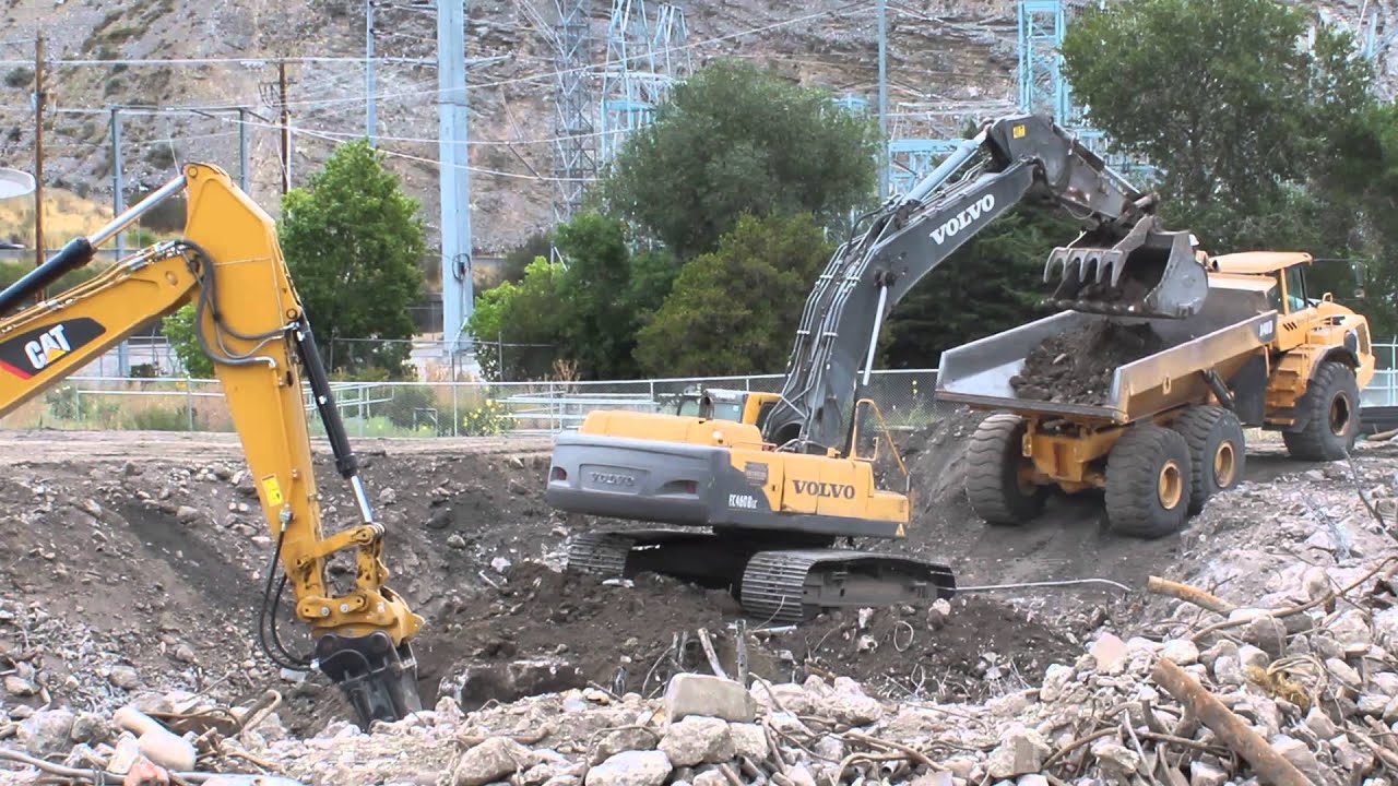 CAT Excavator using and impact hammer attachment while Volvo Ecavator ...