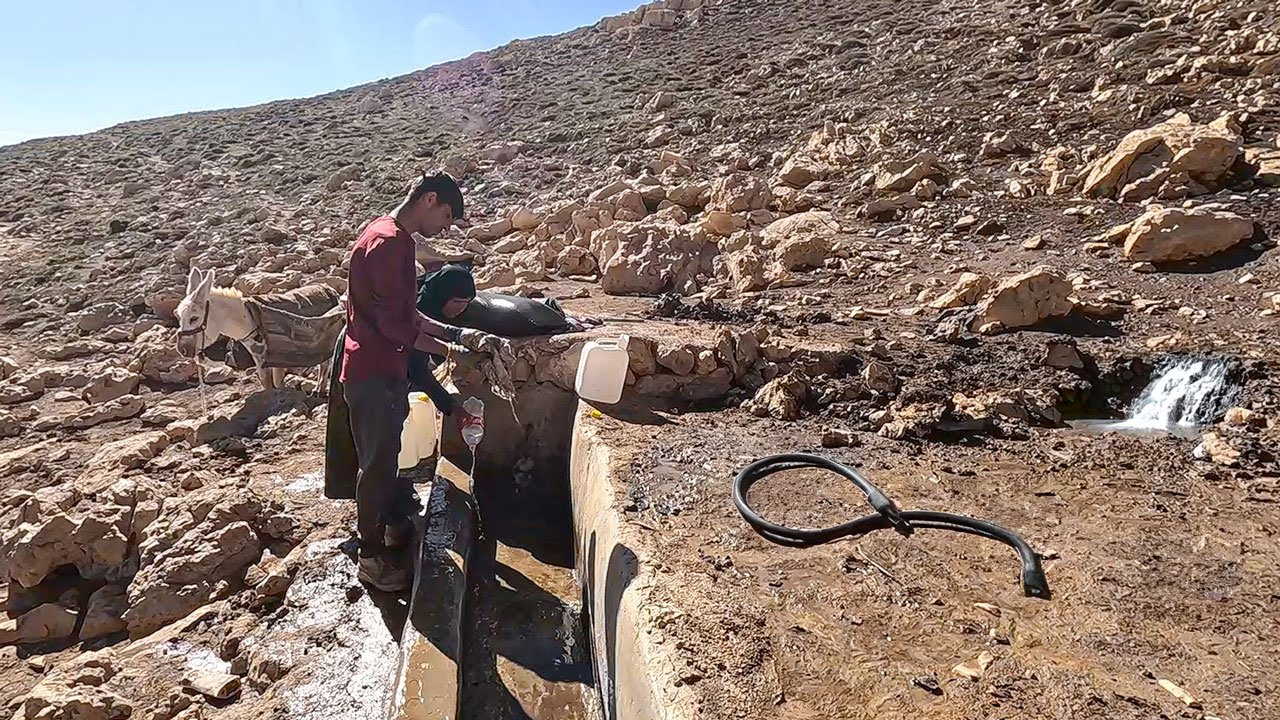 A nomadic family is seen cleaning a water source and repairing water ...