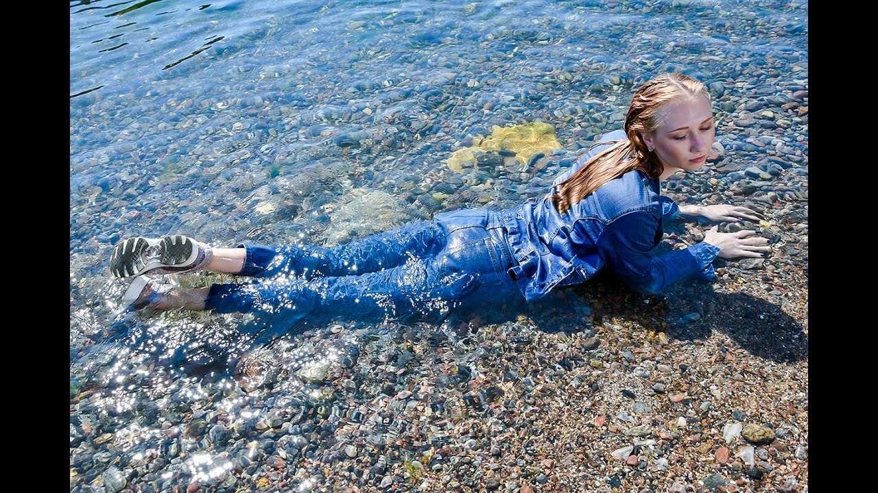 young girl in wet denim jacket and wet jeans posing at sea for wetlook ...