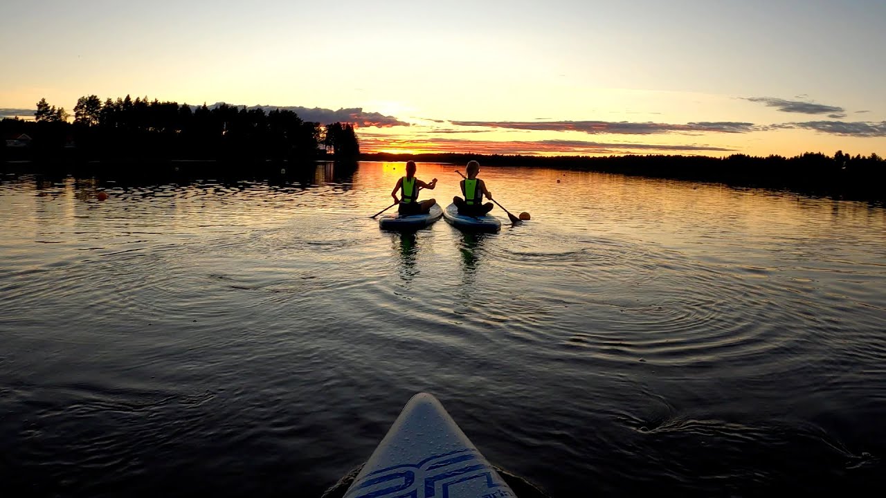 SUP paddling i solnedgången på Lulsundet i Luleå en vacker sommarkväll ...