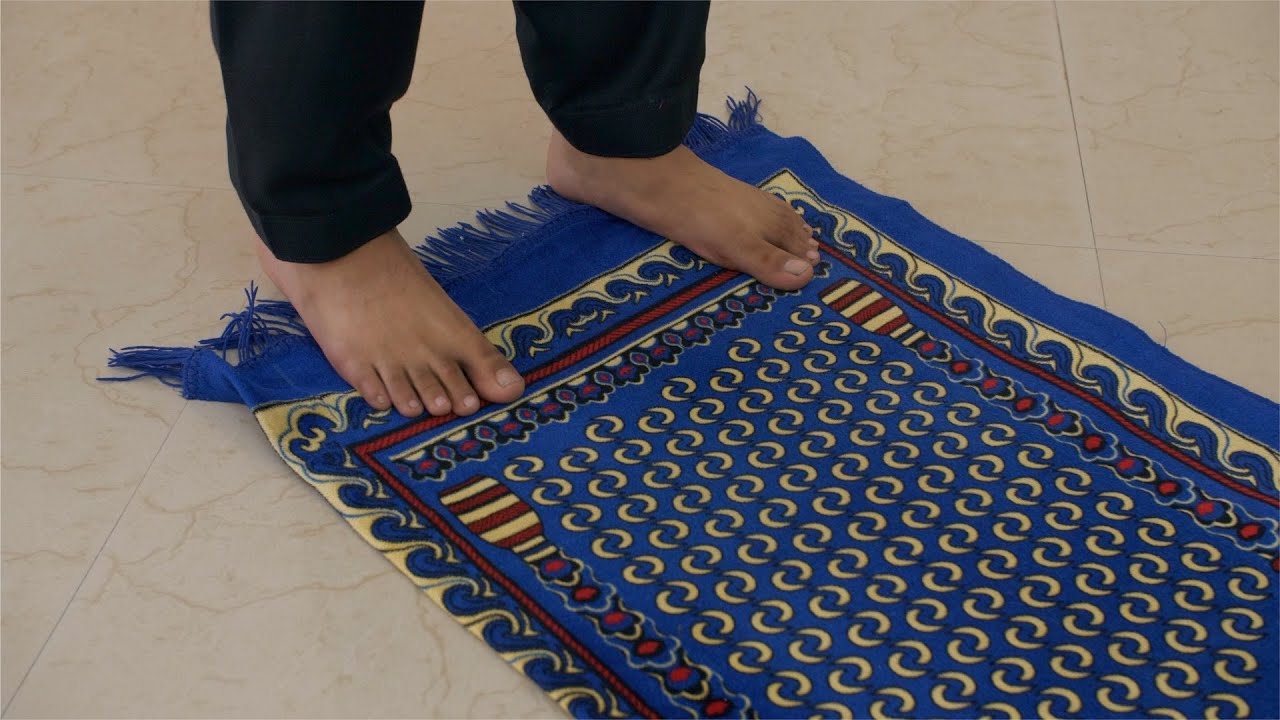 Closeup shot of a young Muslim man's feet standing on a prayer ...