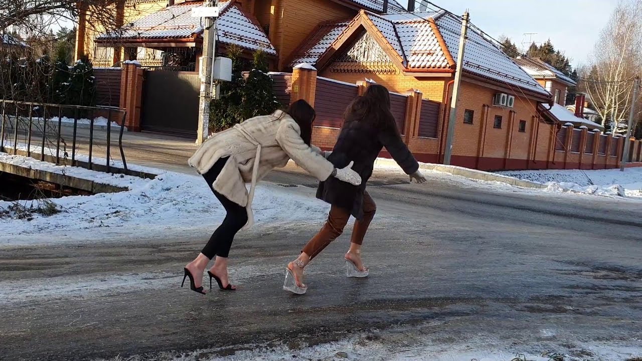 Two sexy models on high heels walking on very slippery ice road, high ...