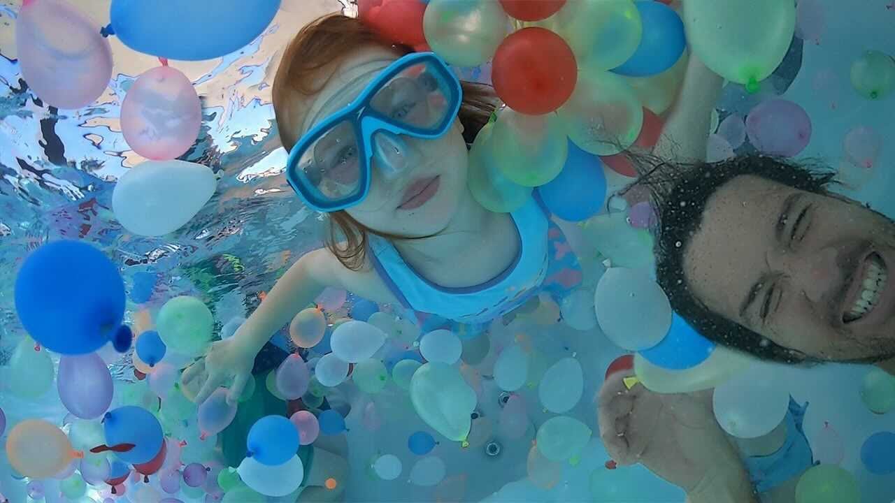Swimming in 1,000 WATER BALLOONS!! Playing in the Pool and family ...
