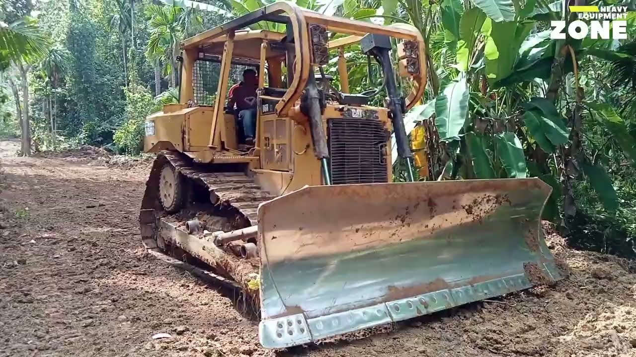 CAT Dozer D6R XL operators push dirt from the top of a hill and pour it ...