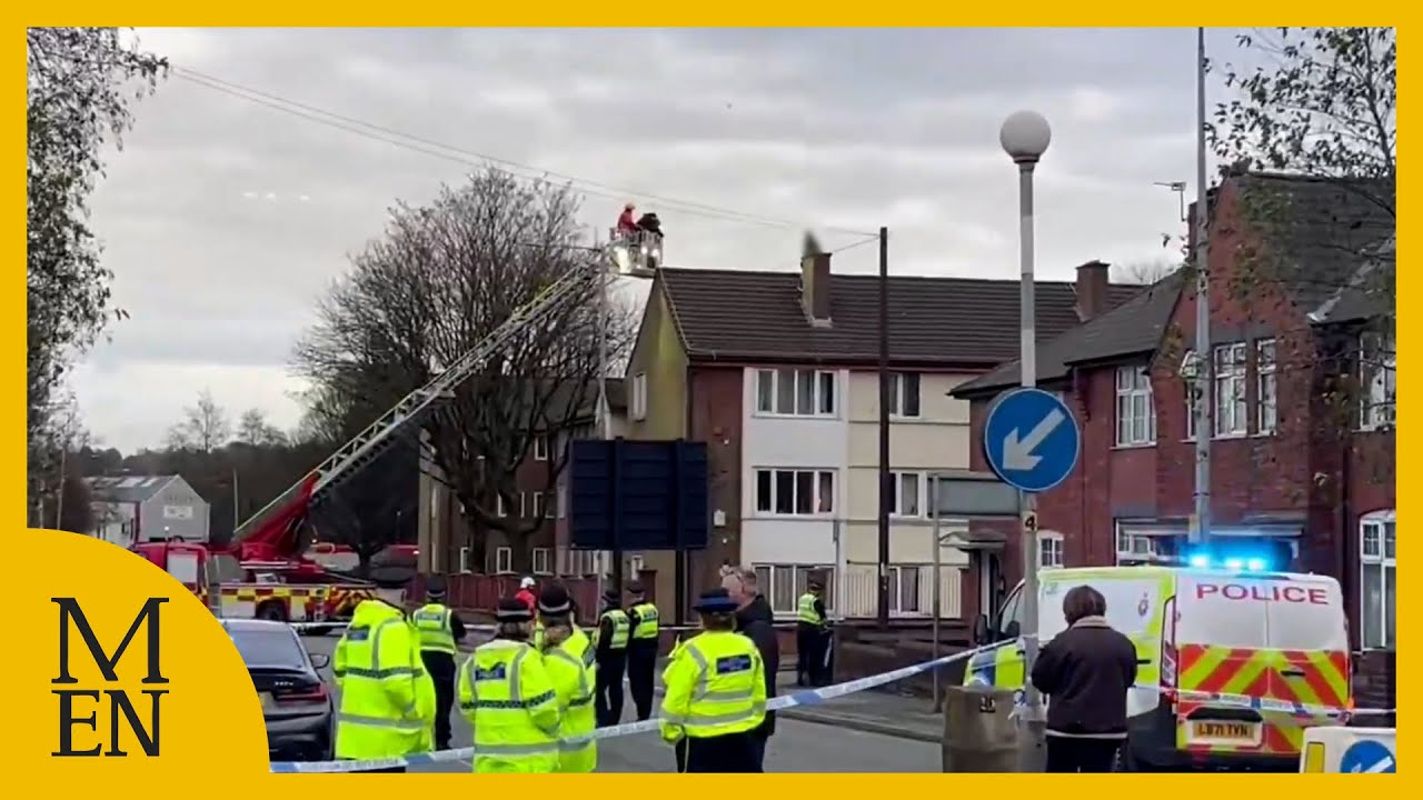 Rooftop standoff as police surround block of flats in Bolton - YouTube