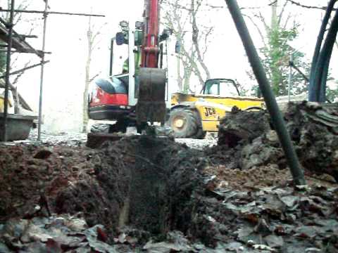 Mini excavator digging out a trench - YouTube