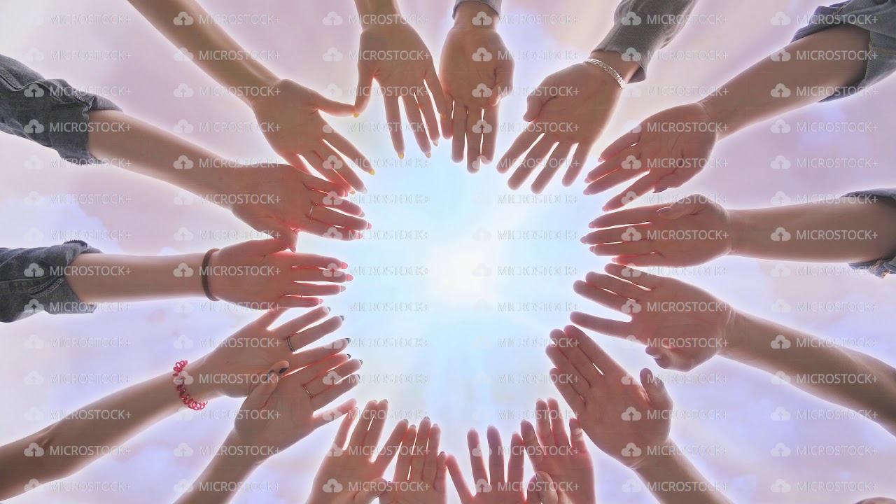 A group of young people make a circle out of their hands. Diverse ...