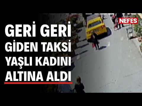 Geri geri giden taksi, yaşlı kadını altına aldı