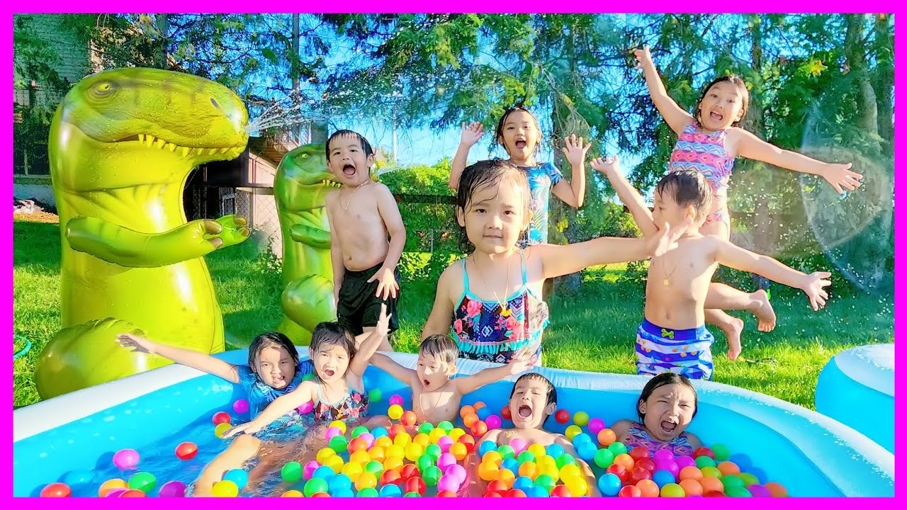 Kids Swimming Outside With Ball Pits In The Swimming Pool and a Giant ...
