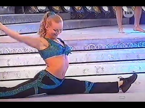 Beautiful fitness flexible girl stretch and flex her body in front of half naked guys, tempting them