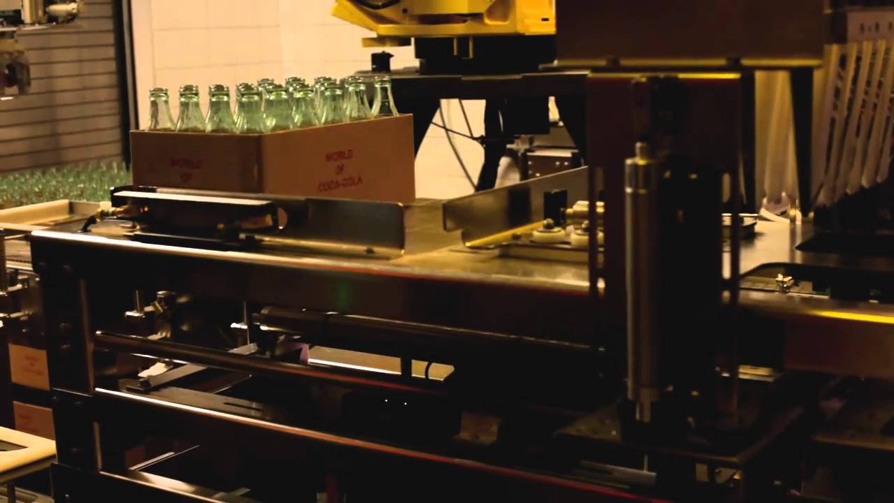 Machine loading bottles at Coke factory - YouTube