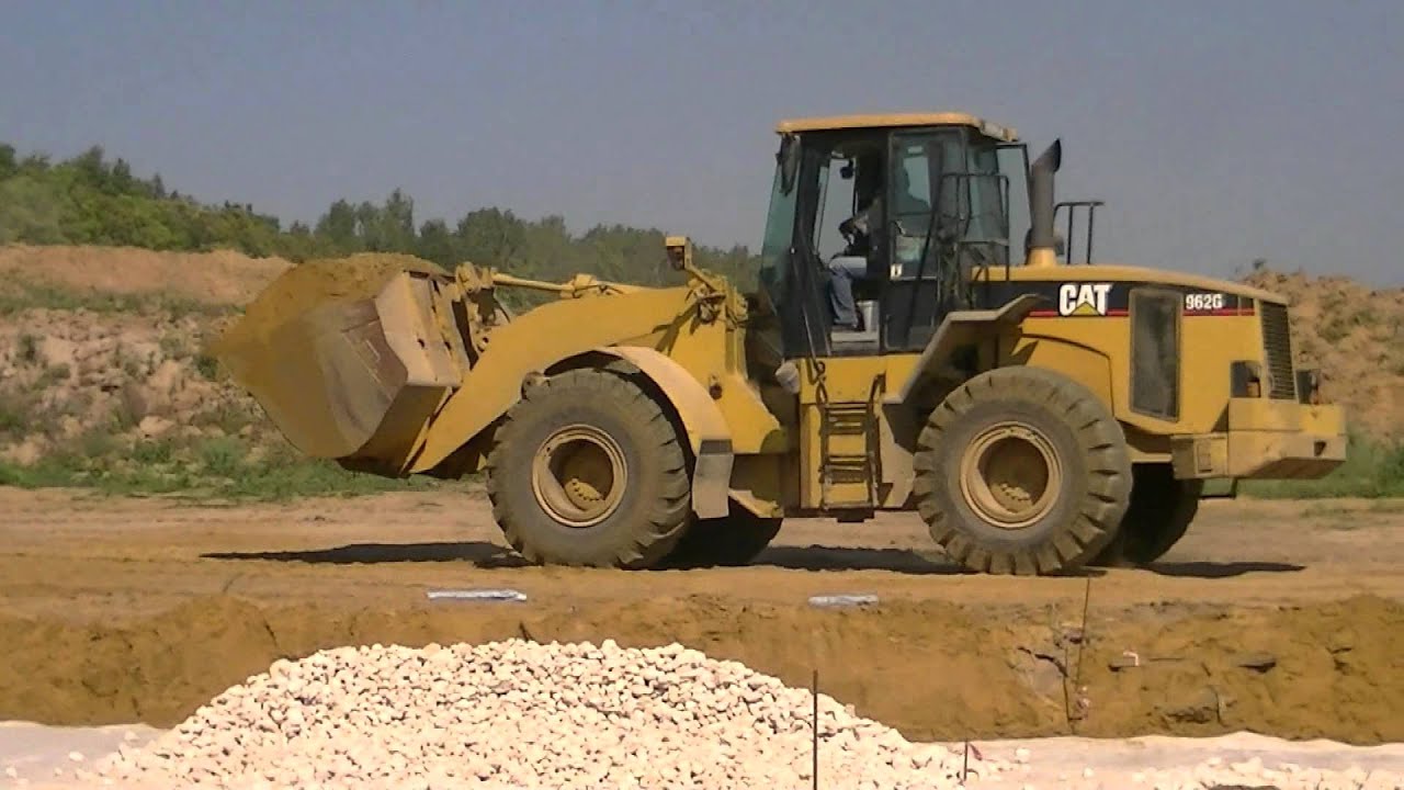 Cat 962G spreading sand - YouTube