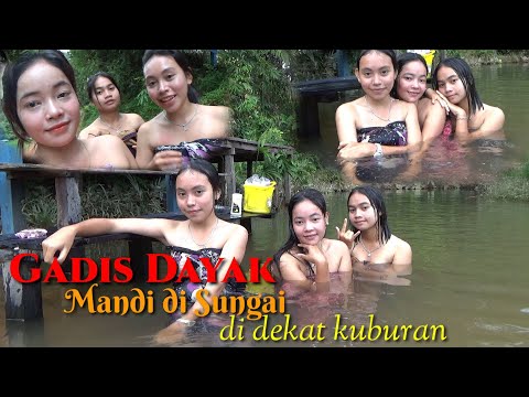 Gadis Dayak mandi di sungai di dekat kuburan