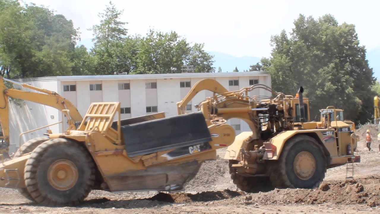 CAT Bulldozer and Cat 631G Scraper working a large construction site ...