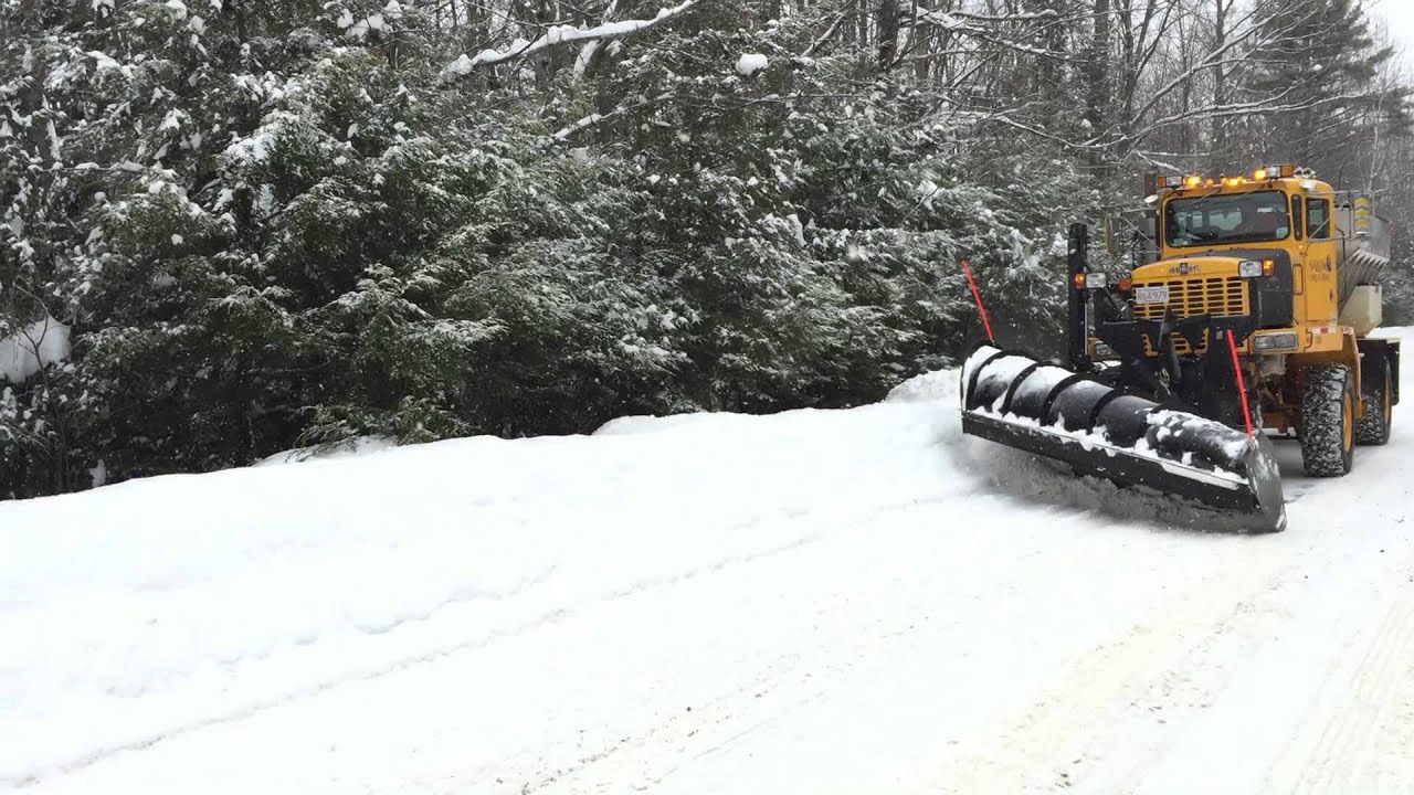 Oshkosh pushing back snow with a wing plow - YouTube