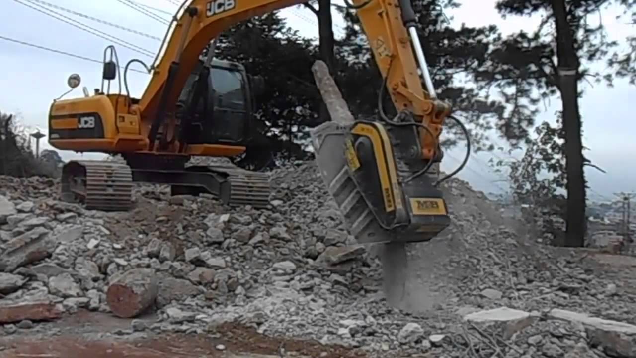 MB crusher bucket crushing concrete pile and railway sleepers - YouTube