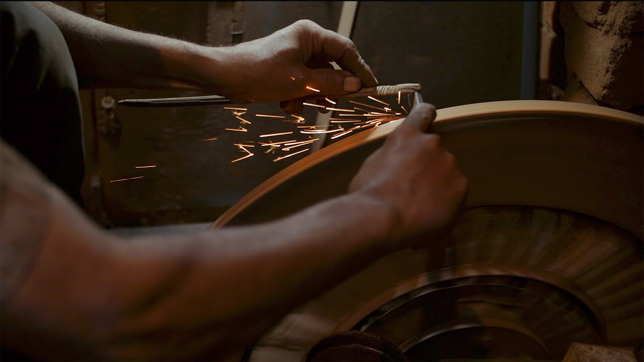 A man sharpening a tool in his hand using a blade sharpening m ...