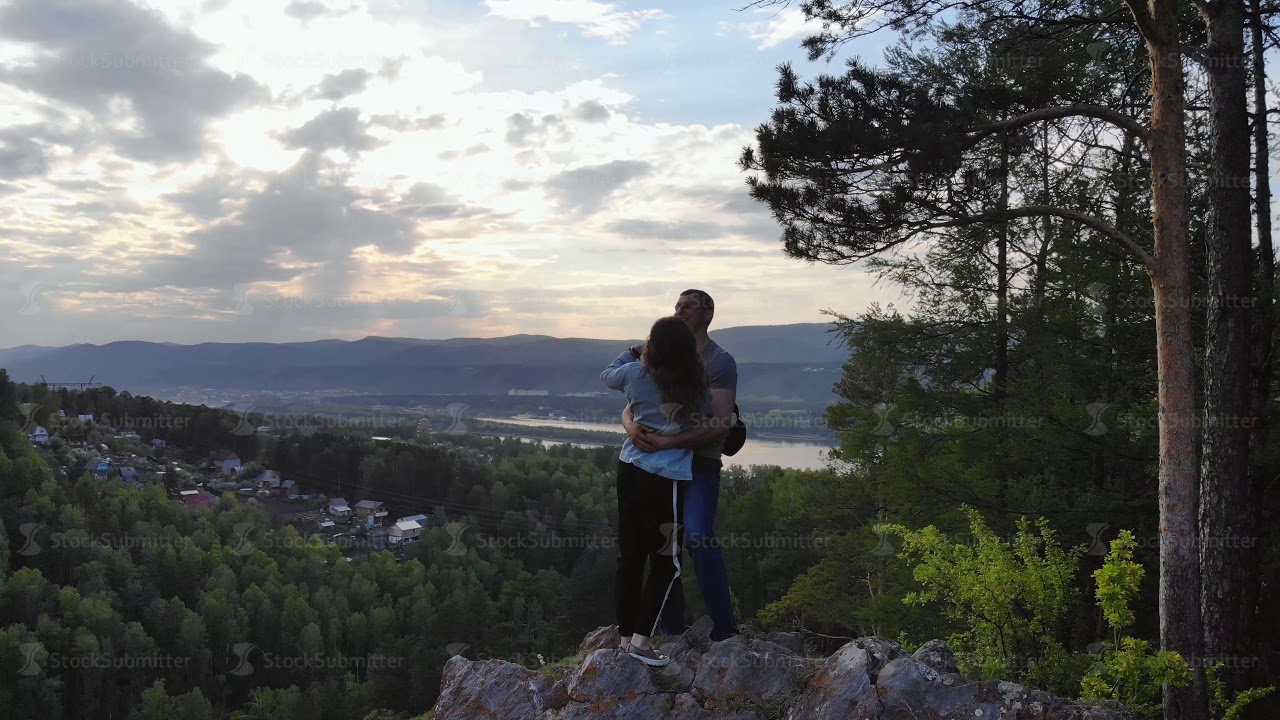 A young couple stand on the edge of a cliff and kiss. - YouTube