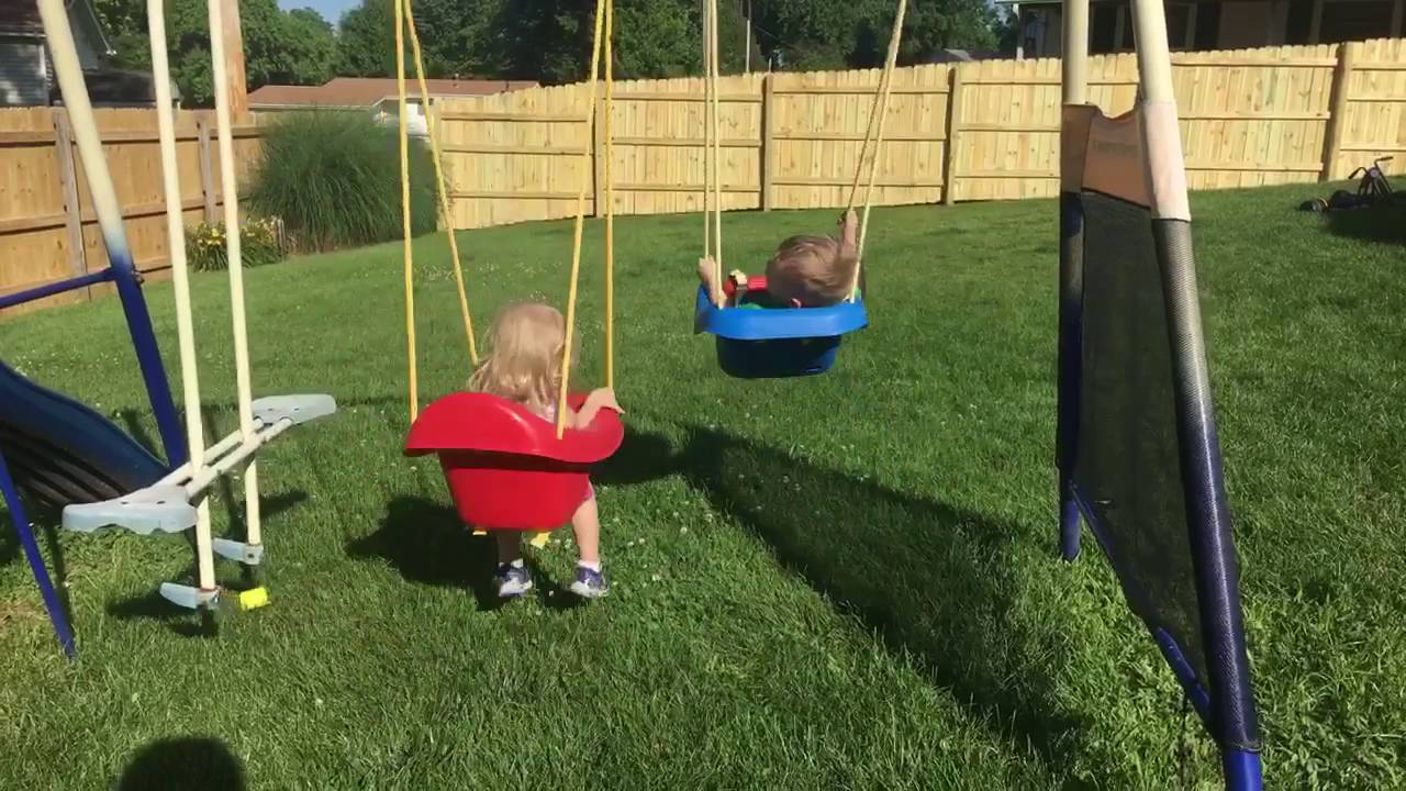 Twin toddlers swinging together - boy girl twins giggle while swinging ...