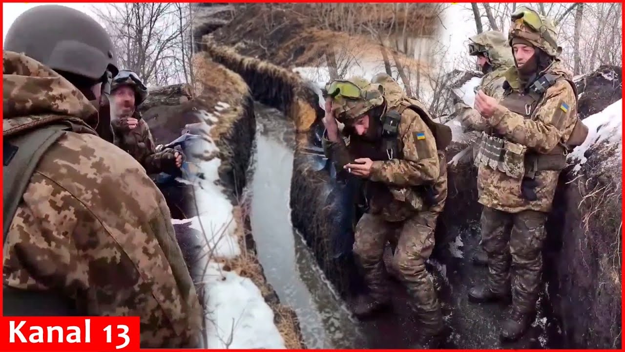 Ukrainian soldiers serving in a water-filled trench are under artillery ...