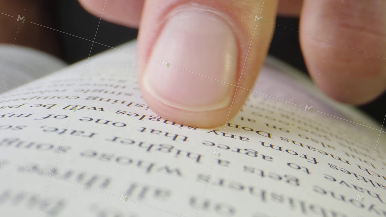 Macro close-up of finger moving through page of music publishing book ...