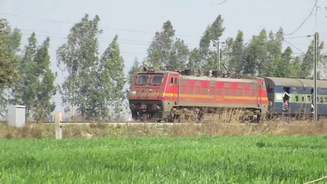 Electrified Poorabiya express racing past lush green fields at Mps with ...