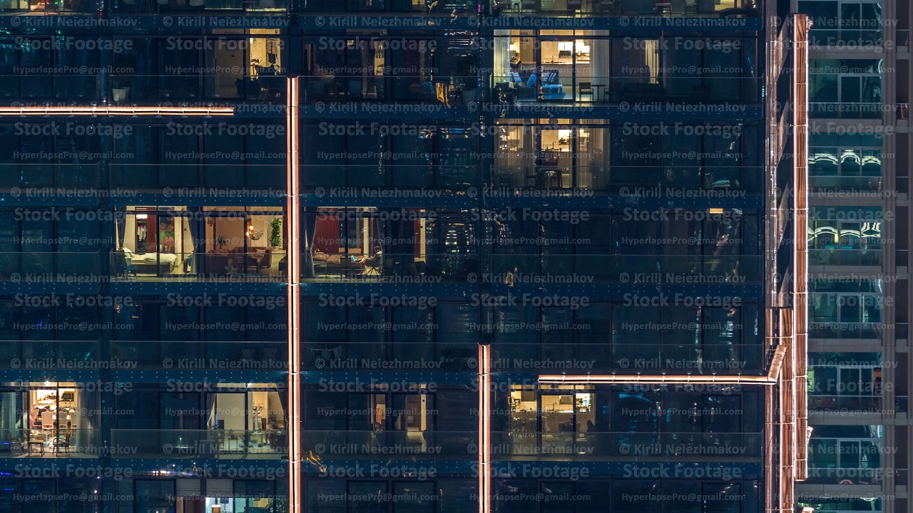 Lights in windows of modern multiple story building in urban setting at ...
